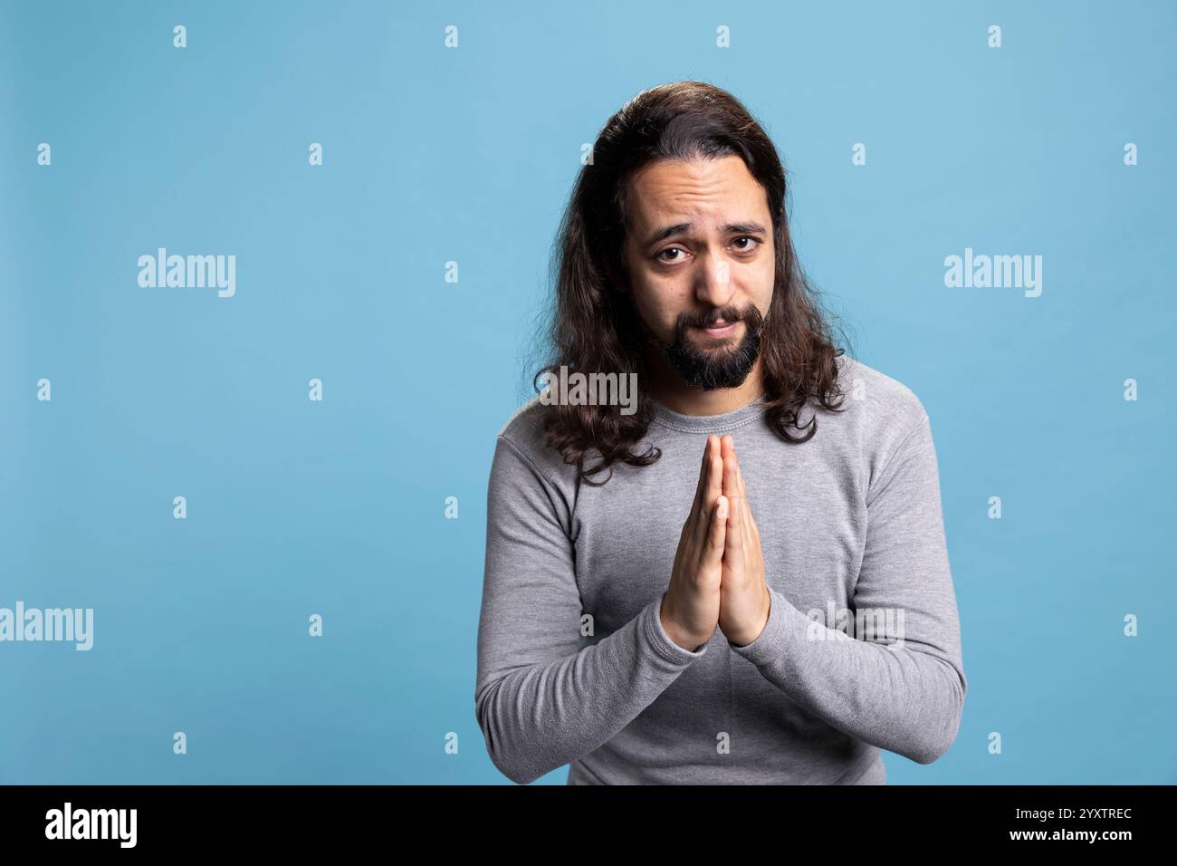 Spiritual guy praying to God and asking for forgiveness in studio ...