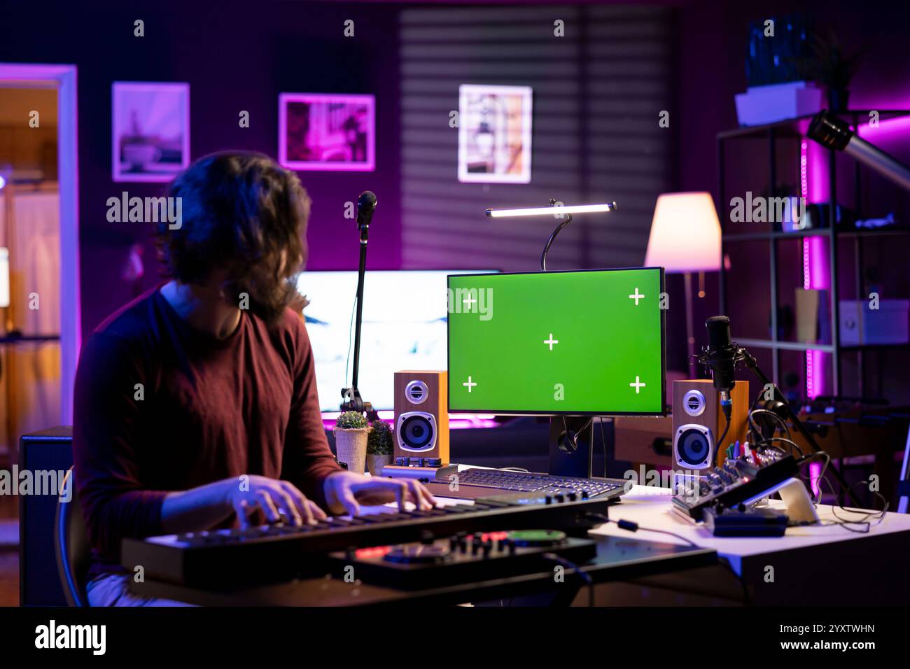 Sound engineer hitting electronic piano notes and following tutorials ...