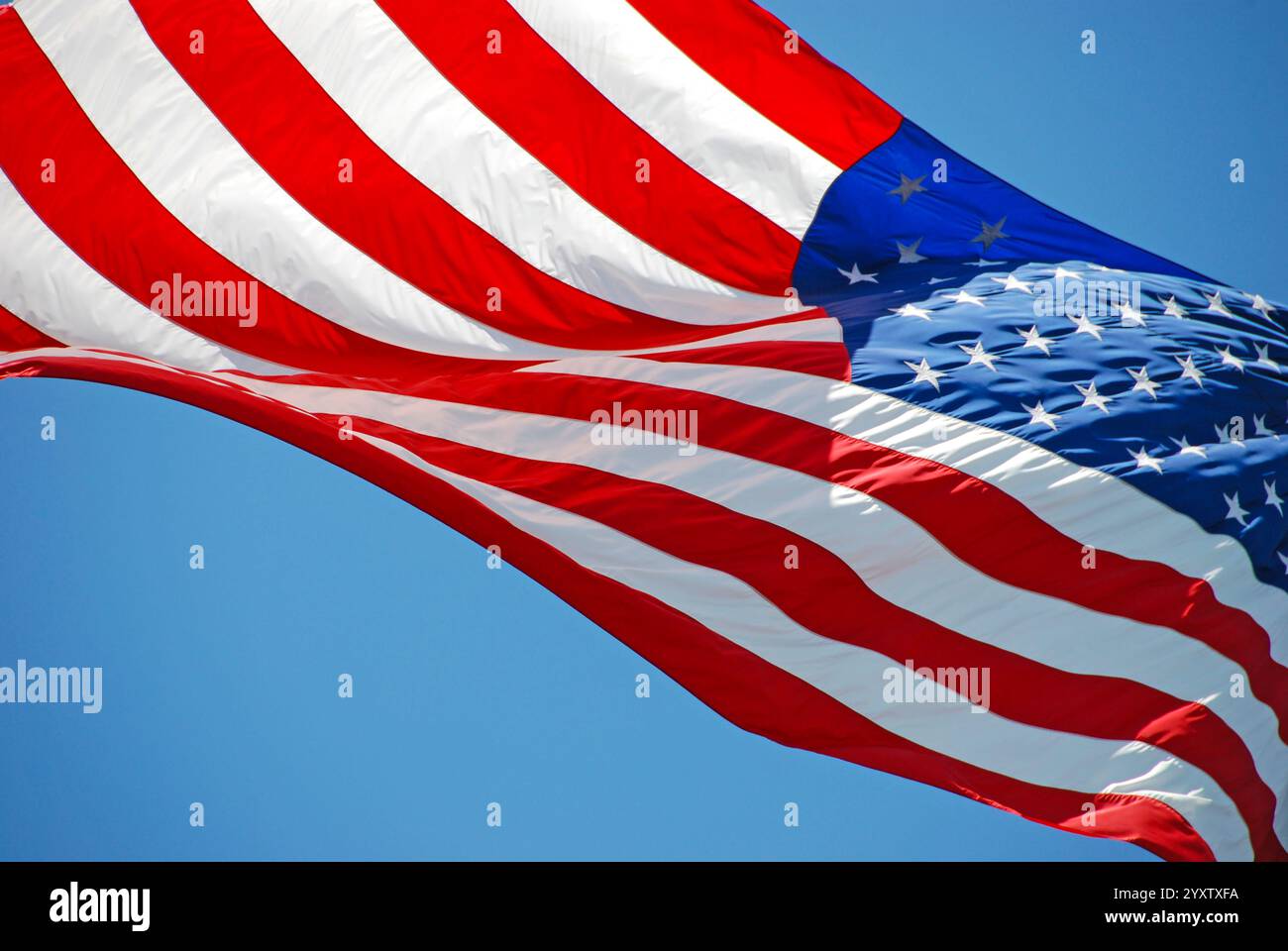 American Flag Waving Diagonally Against Blue Sky Stock Photo - Alamy