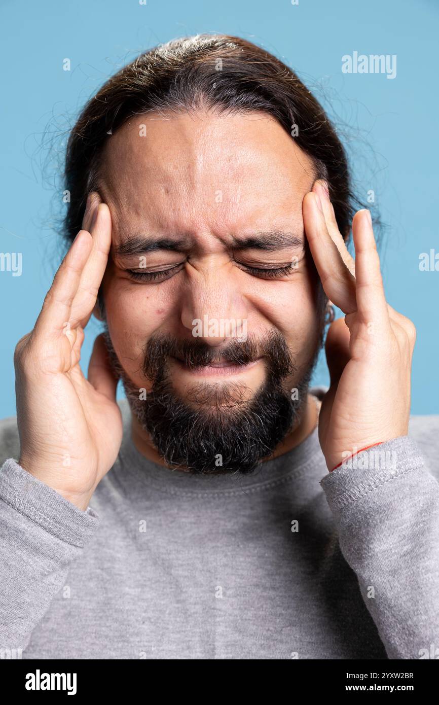 Young guy rubbing temples hi-res stock photography and images - Alamy