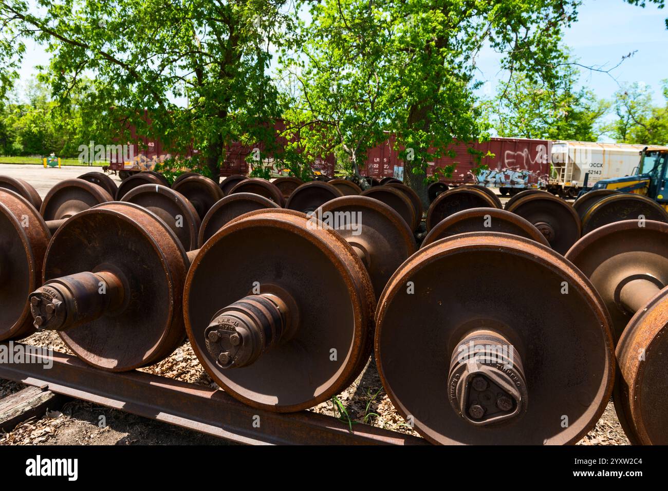 Rows of new rusty box car wheel axil set stored in railroad switch yard ...