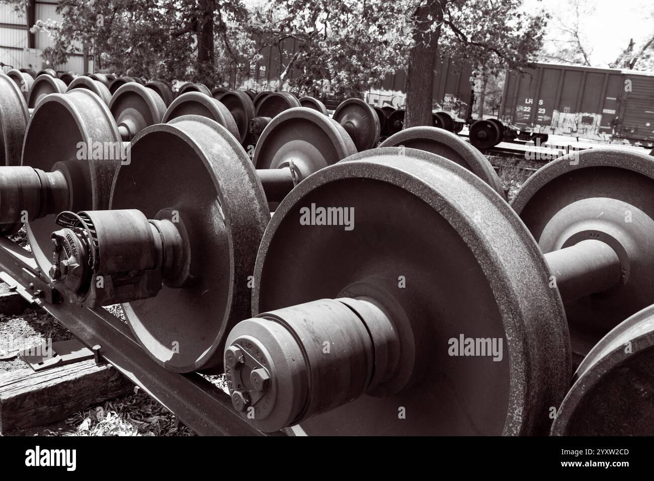 Rows of new rusty box car wheel axil set stored in railroad switch yard ...