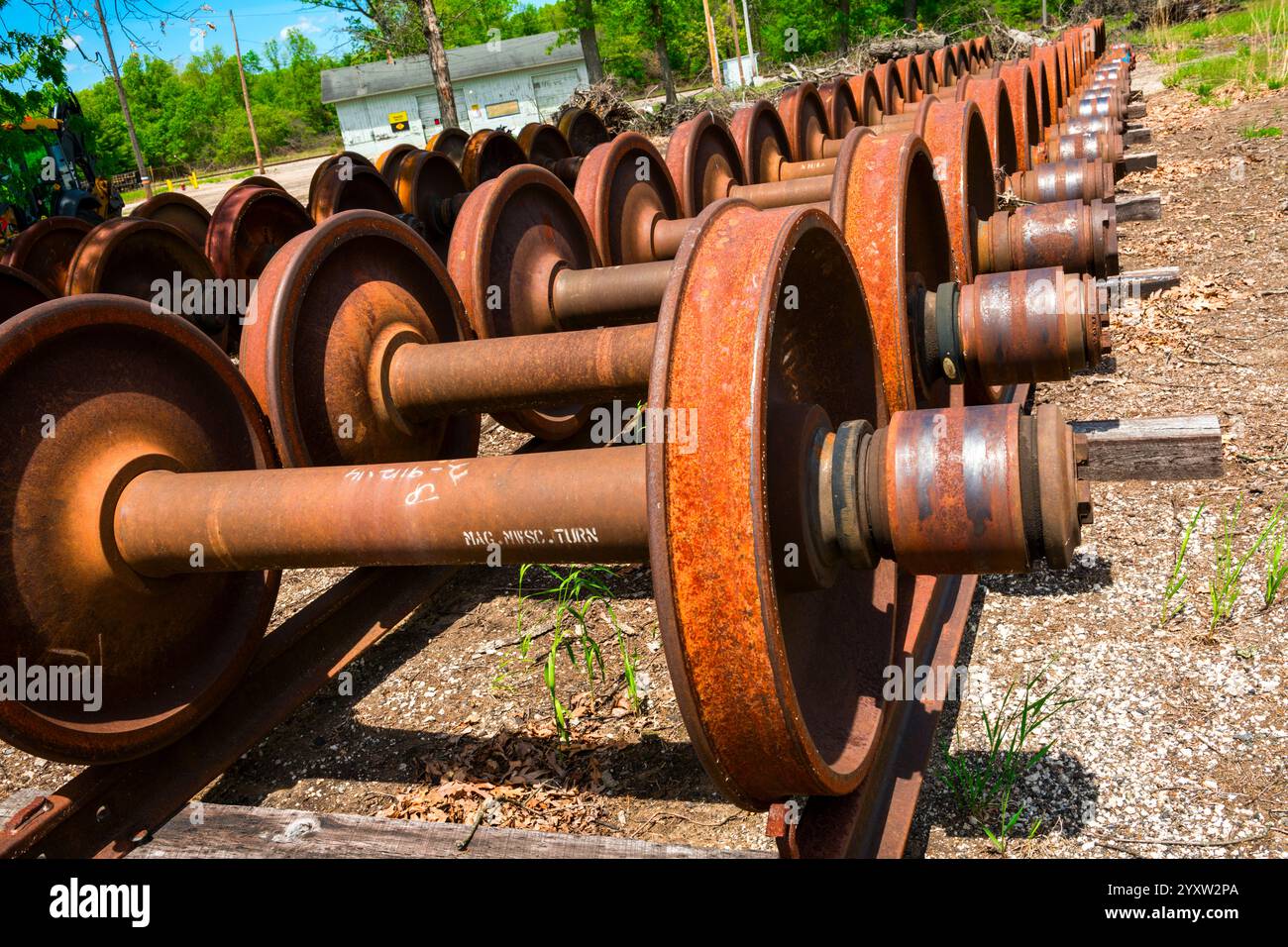 Rows of new rusty box car wheel axil set stored in railroad switch yard ...