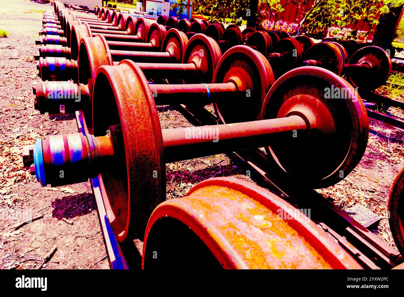 Rows of new rusty box car wheel axil set stored in railroad switch yard ...