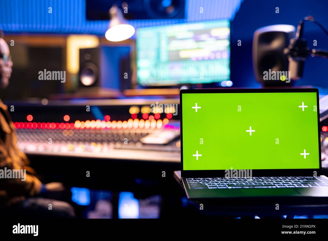 Focused audio engineer recording tracks on control panel board next to ...