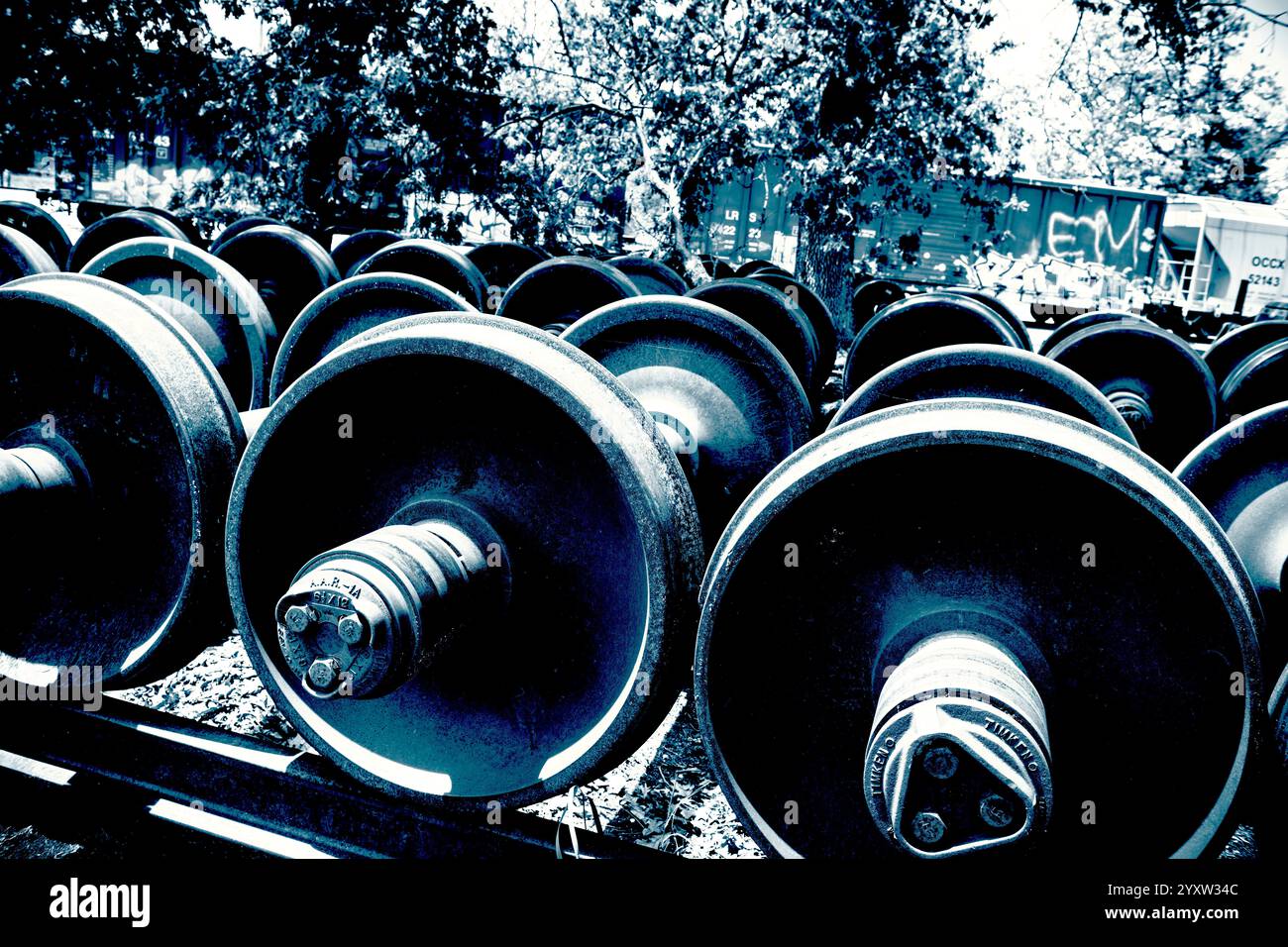 Rows of new rusty box car wheel axil set stored in railroad switch yard ...