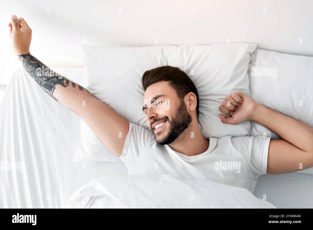 Awakening concept. Happy rested wellslept man waking up in morning and ...