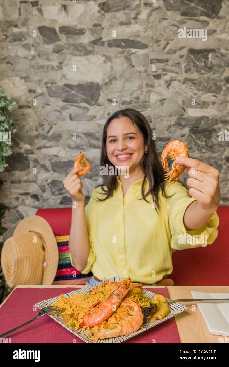 Woman showing shrimps while eating traditional ecuadorian seafood dish ...