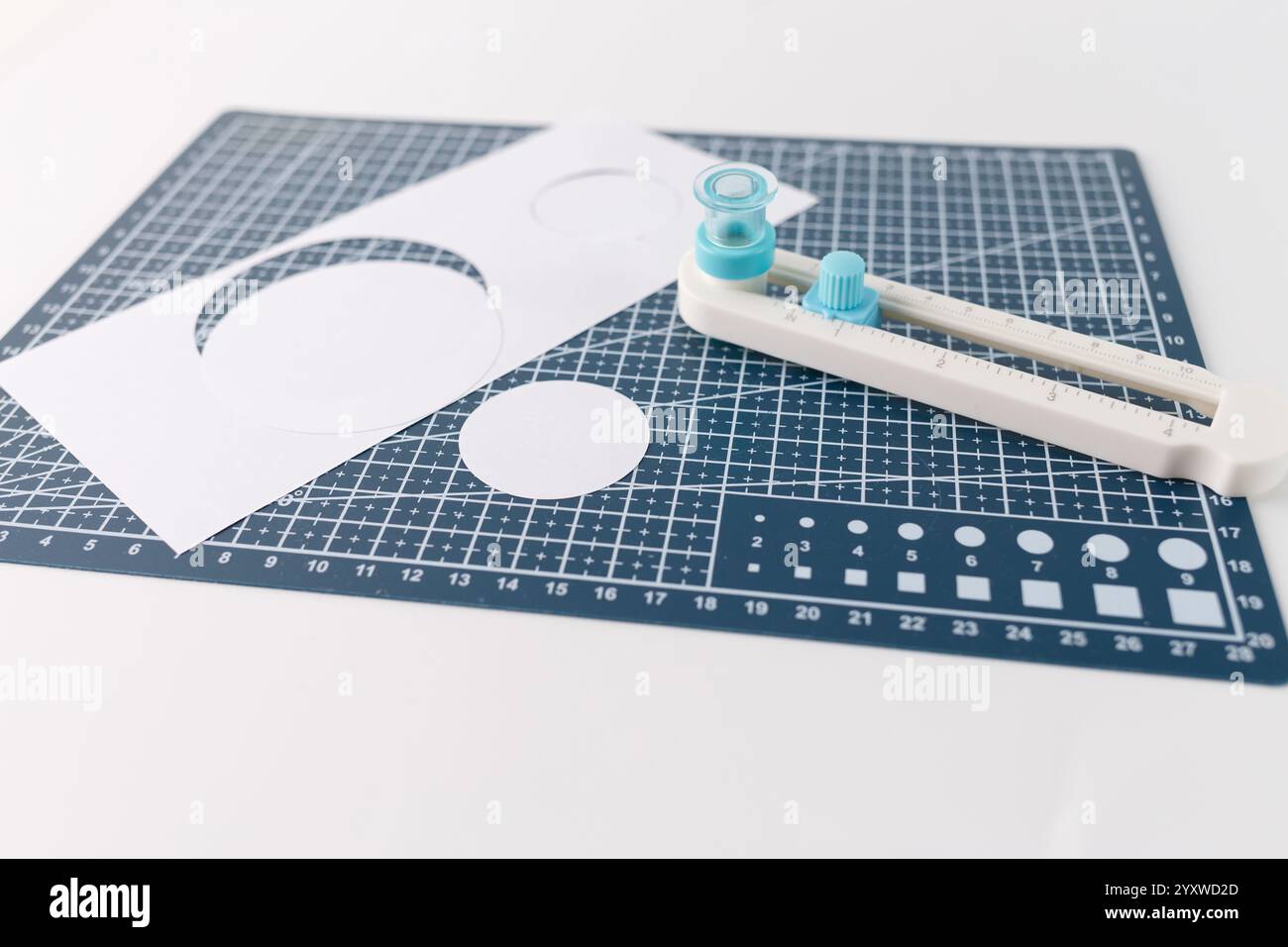 crafting tools and materials used for cutting circles. blue cutting mat with a grid markings ...