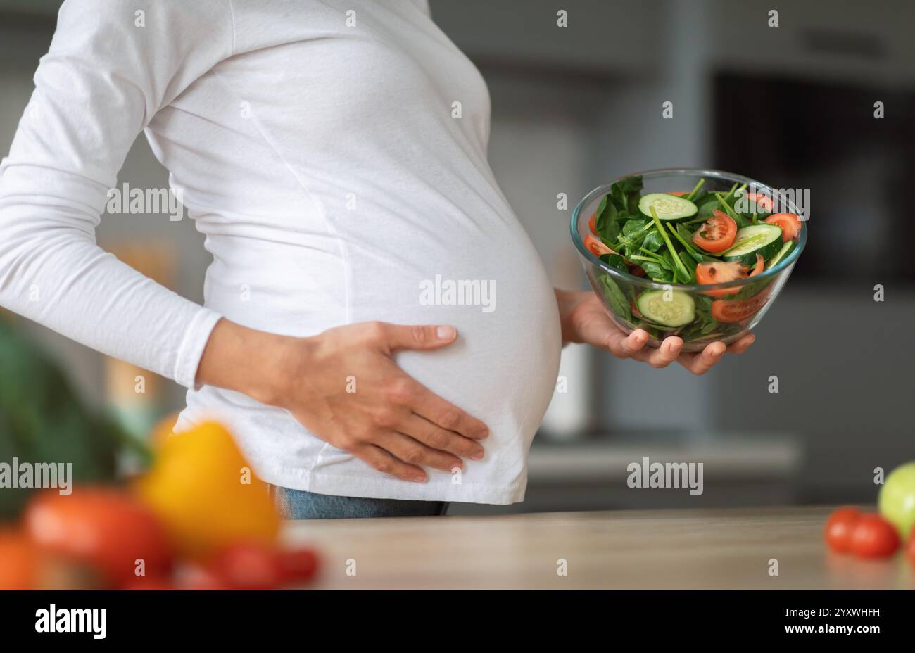 Healthy eating during pregnancy with fresh salad in a kitchen setting ...