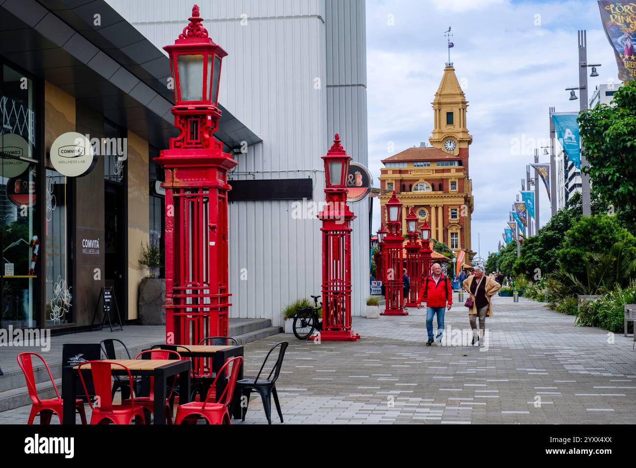 People walking along the red fence on Quay St sidewalk, Auckland ...