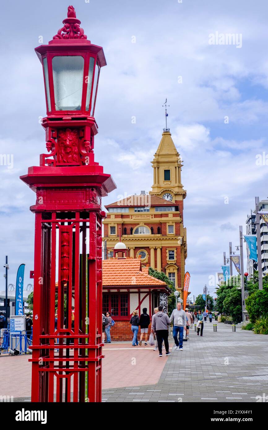 People walking along the red fence on Quay St sidewalk, Auckland ...