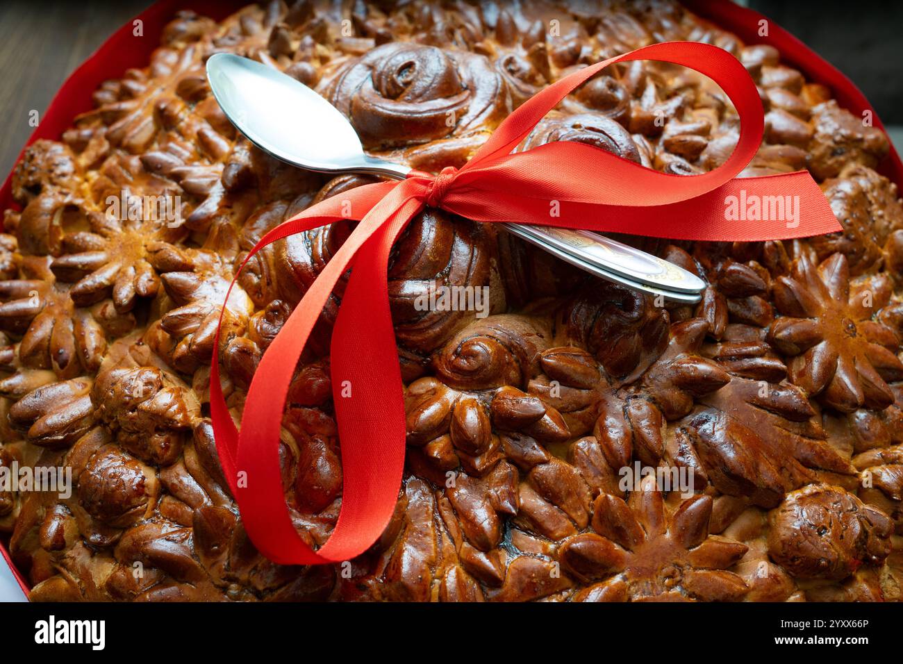 This stunning cake features intricate floral designs and a shiny silver ...
