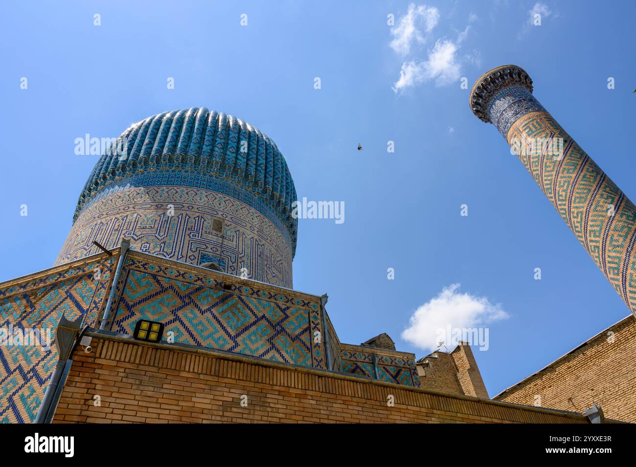 The mosque with a turquoise carved dome and minaret with patterns and ...