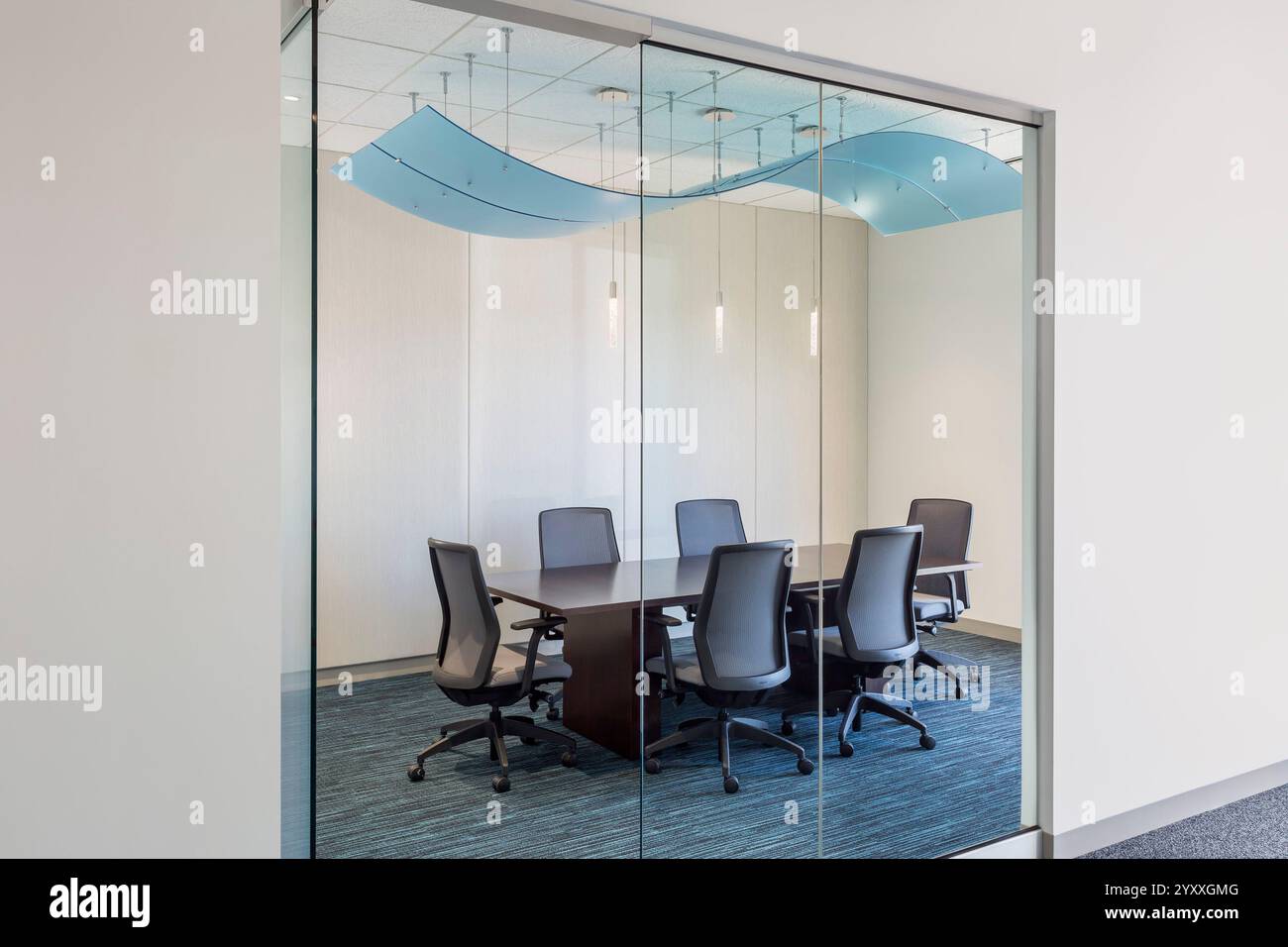 Conference room seen through window with wave shaped ceiling light ...