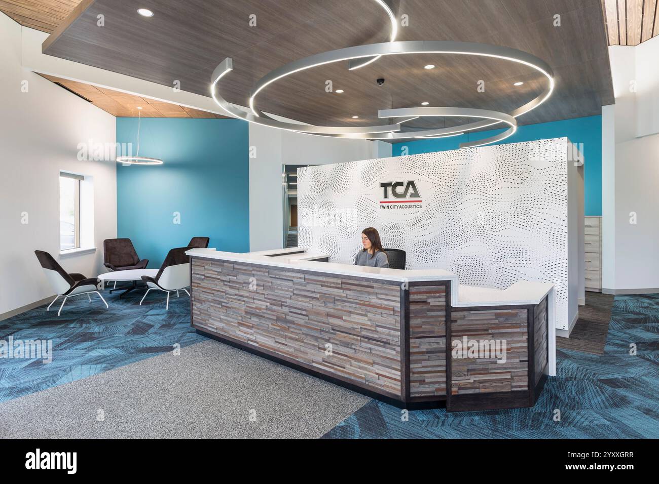 Woman behind desk in entrance reception area of new office space with ...