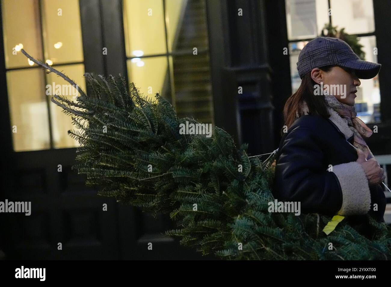 Kiwha Lee, a visual artist from New York, carries a Christmas tree from ...