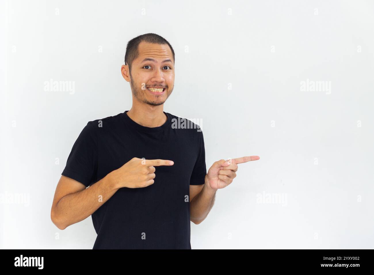 Young Adult Asian men wearing black shirt pointing finger to the right ...
