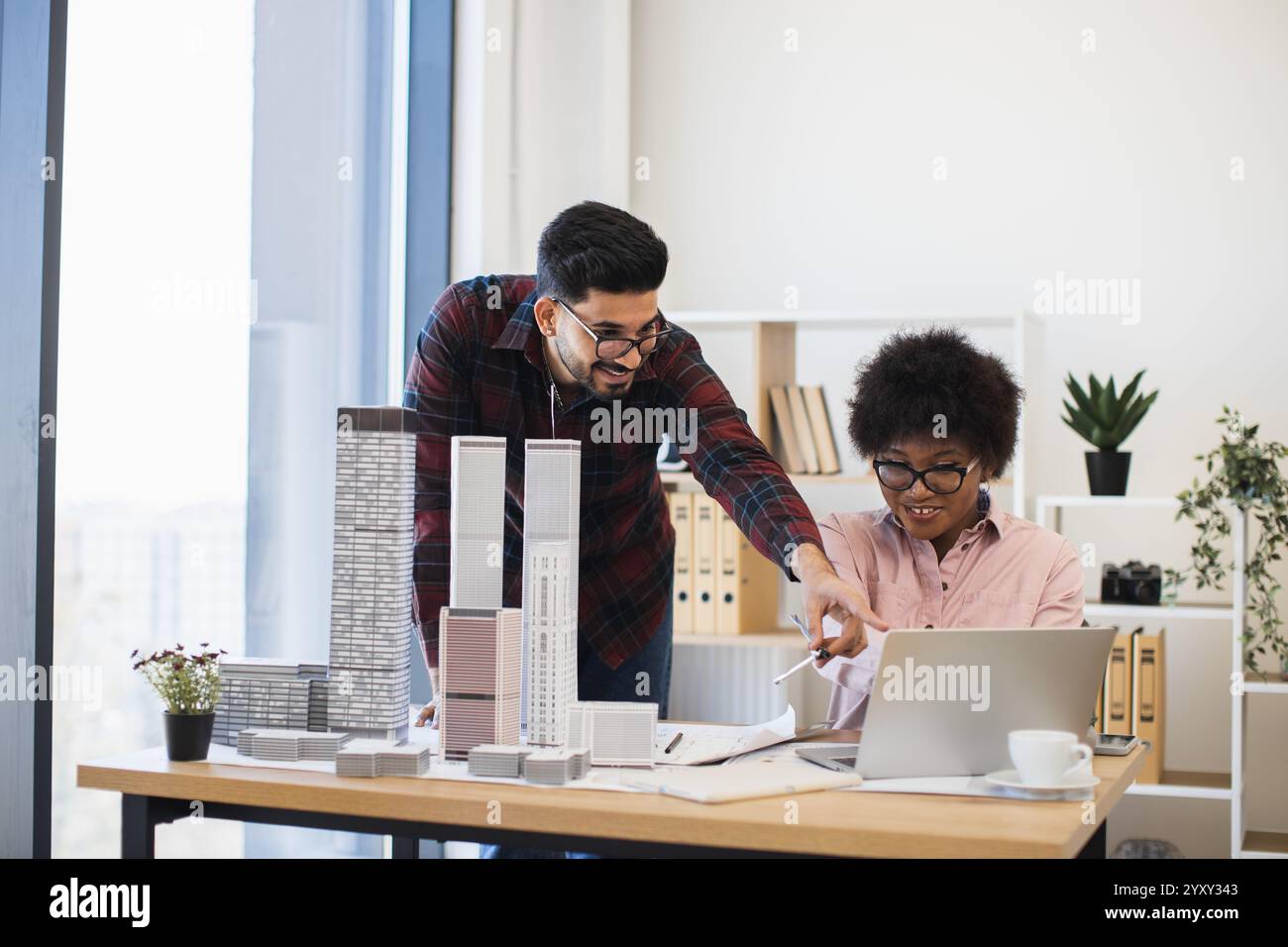 Indian man and African woman collaborate on architectural model in ...