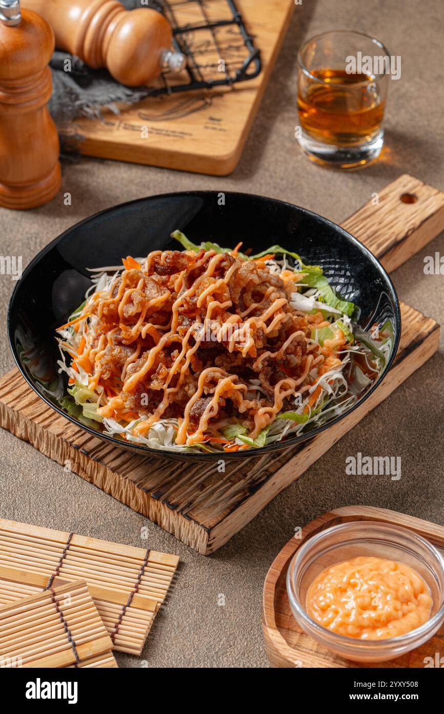 Crispy beef fillet pieces with mayonnaise plating on a black plate ...