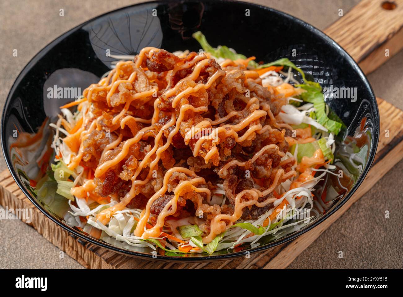 Crispy beef fillet pieces with mayonnaise plating on a black plate ...
