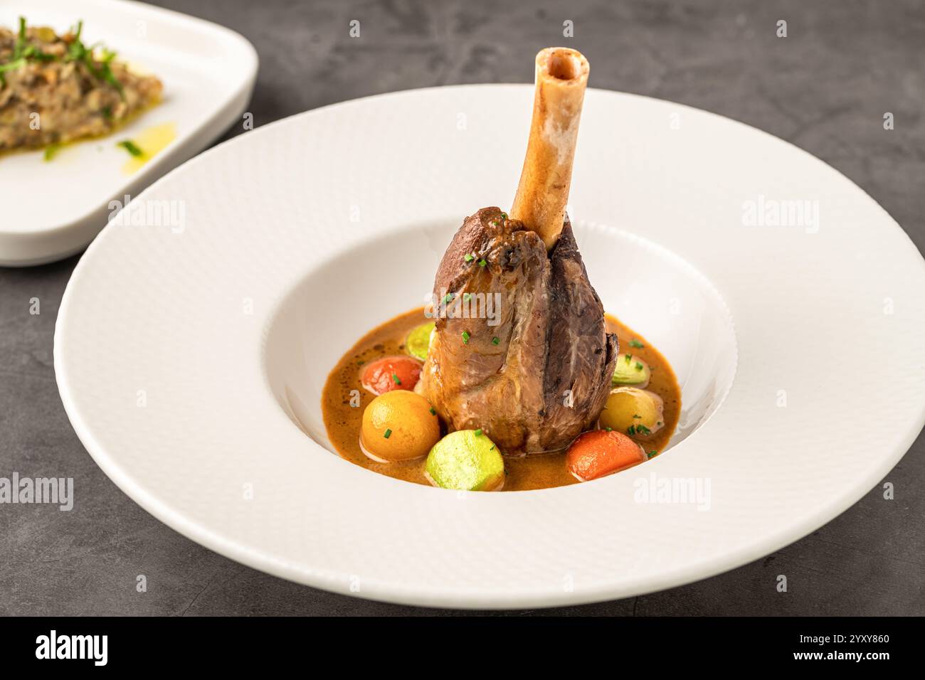 Traditional slow-cooked braised lamb knuckle or lamb shank with sauces ...