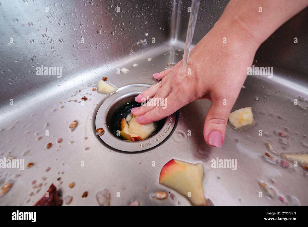 Removing food scraps from a kitchen sink with a garbage disposer and ...