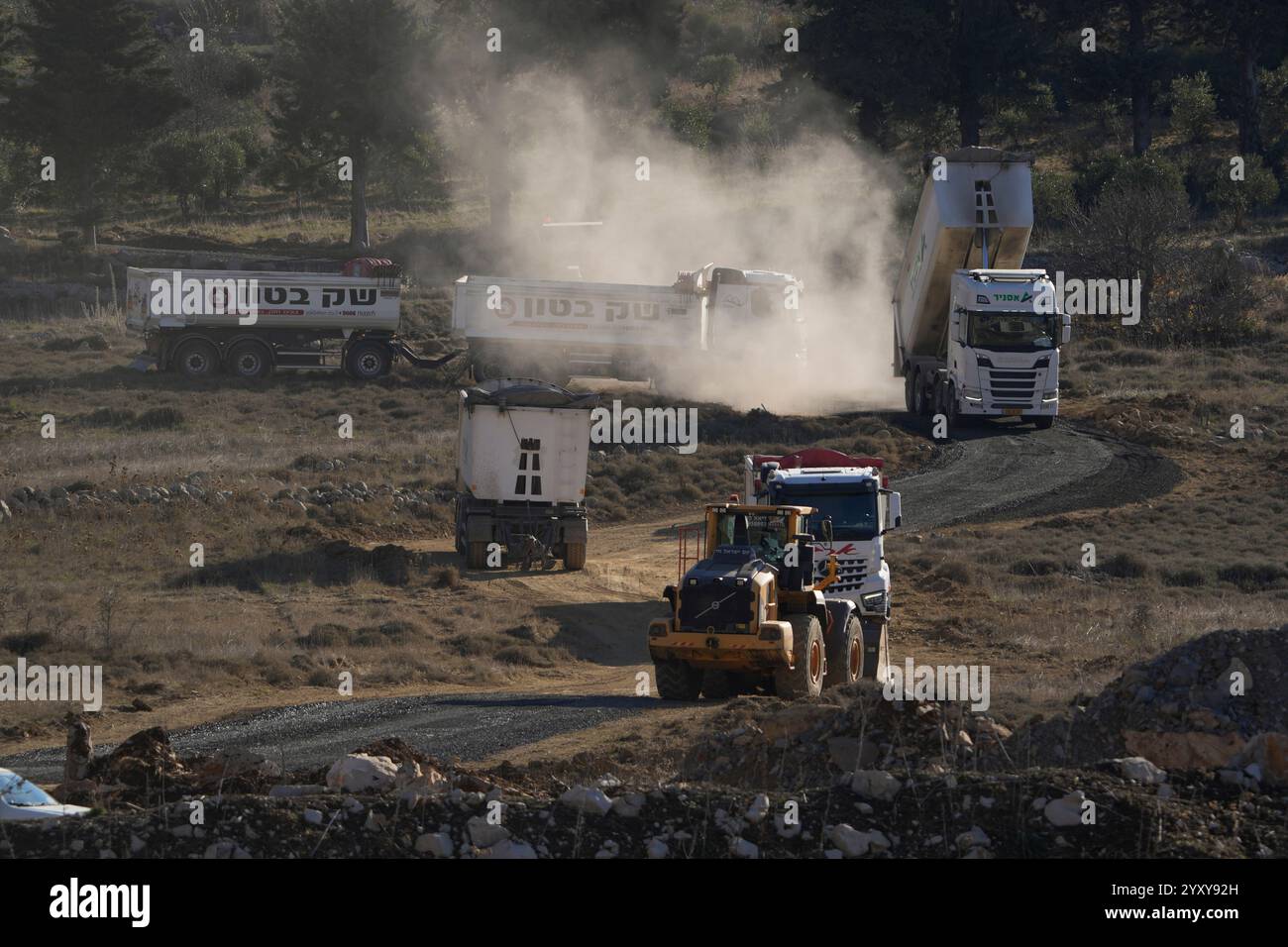 Israeli trucks work making a road inside the buffer zone near the so ...