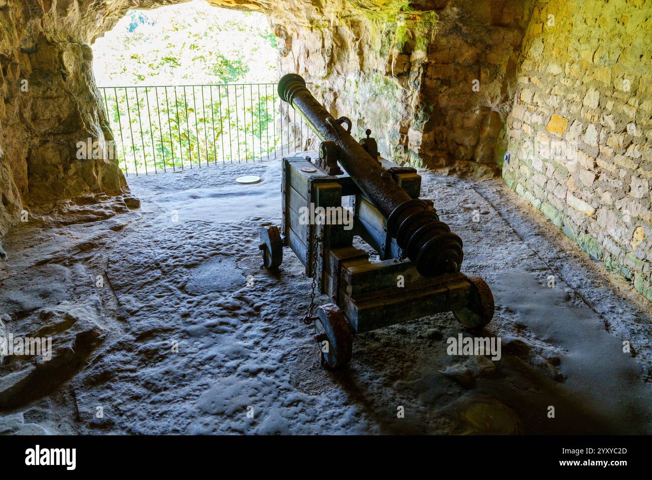 Ancient rusty cannon on display in a dark room of a castle in ...