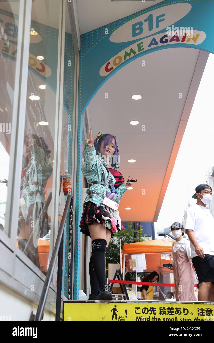 Girl standing at the entrance of a B1F store in Takeshita Street ...
