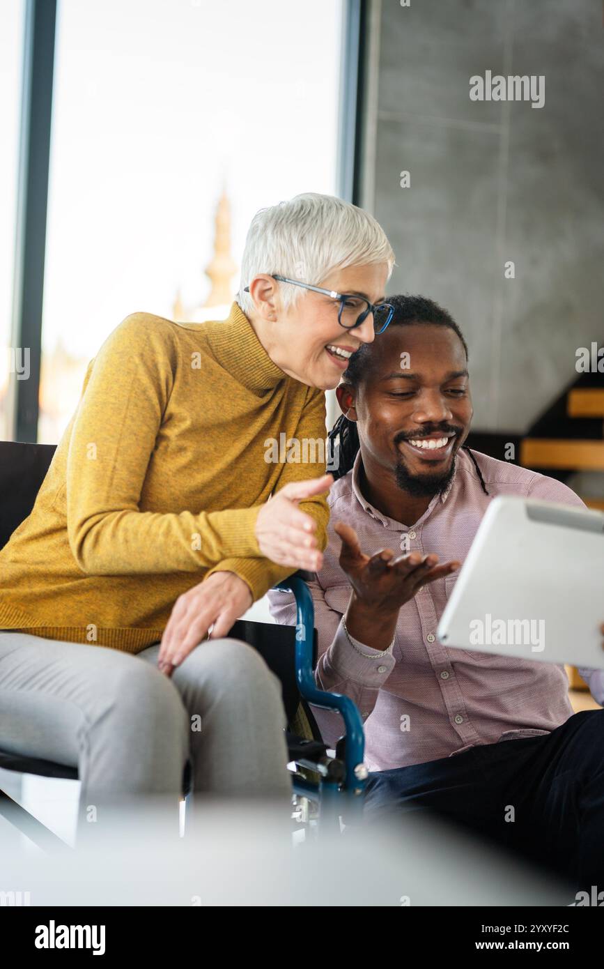 Diverse business colleagues collaborating. Woman in wheelchair working ...