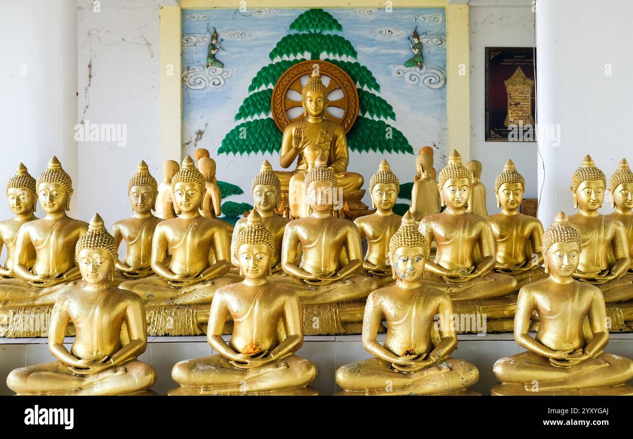 A serene temple in Thailand features rows of golden Buddha statues ...