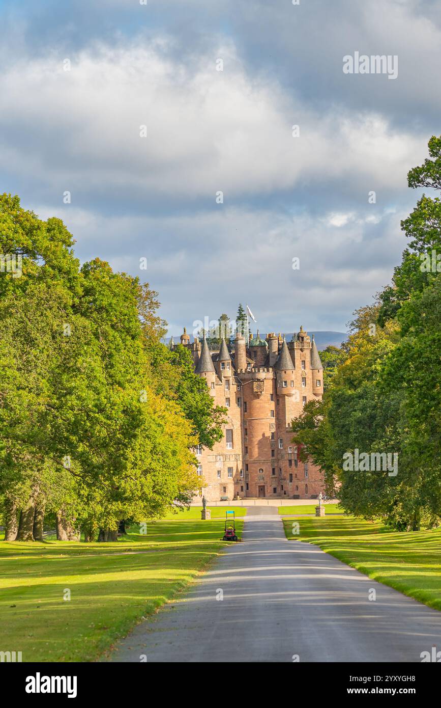 The tree-lined avenue to the old historical Glamis Castle in Scotland with green trees Stock ...