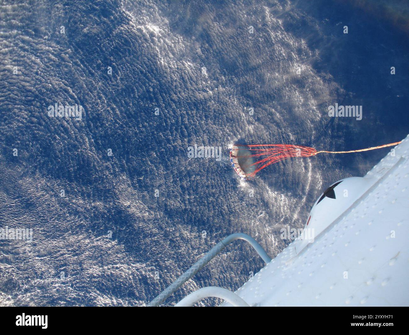 Helicopter collecting water in a bucket from a pond for fire fighting ...