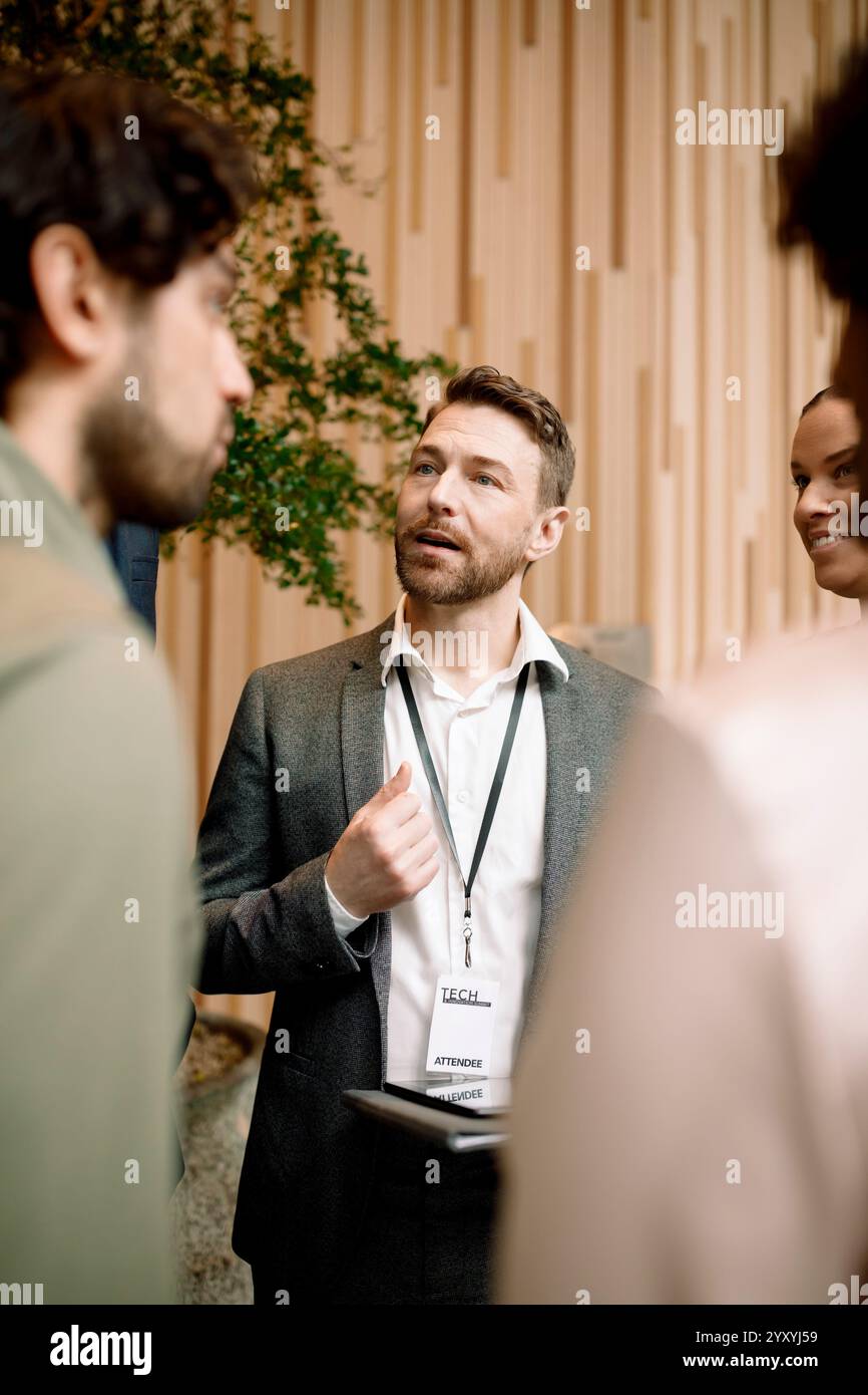 Mature businessman talking with delegates in seminar at convention ...