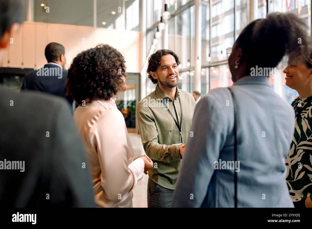 Businessman interacting with female entrepreneurs in networking event ...