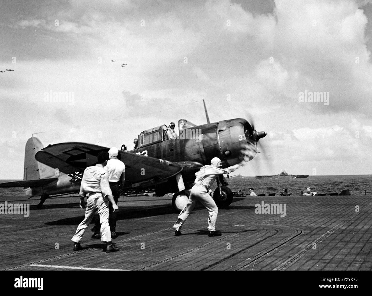 A U.S. Navy launch officer on board USS Lexington (CV-16) waves the ...