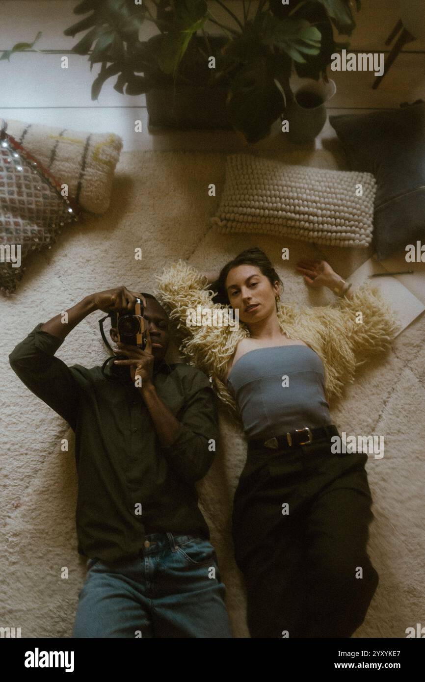 Directly above portrait of young woman lying down beside boyfriend ...