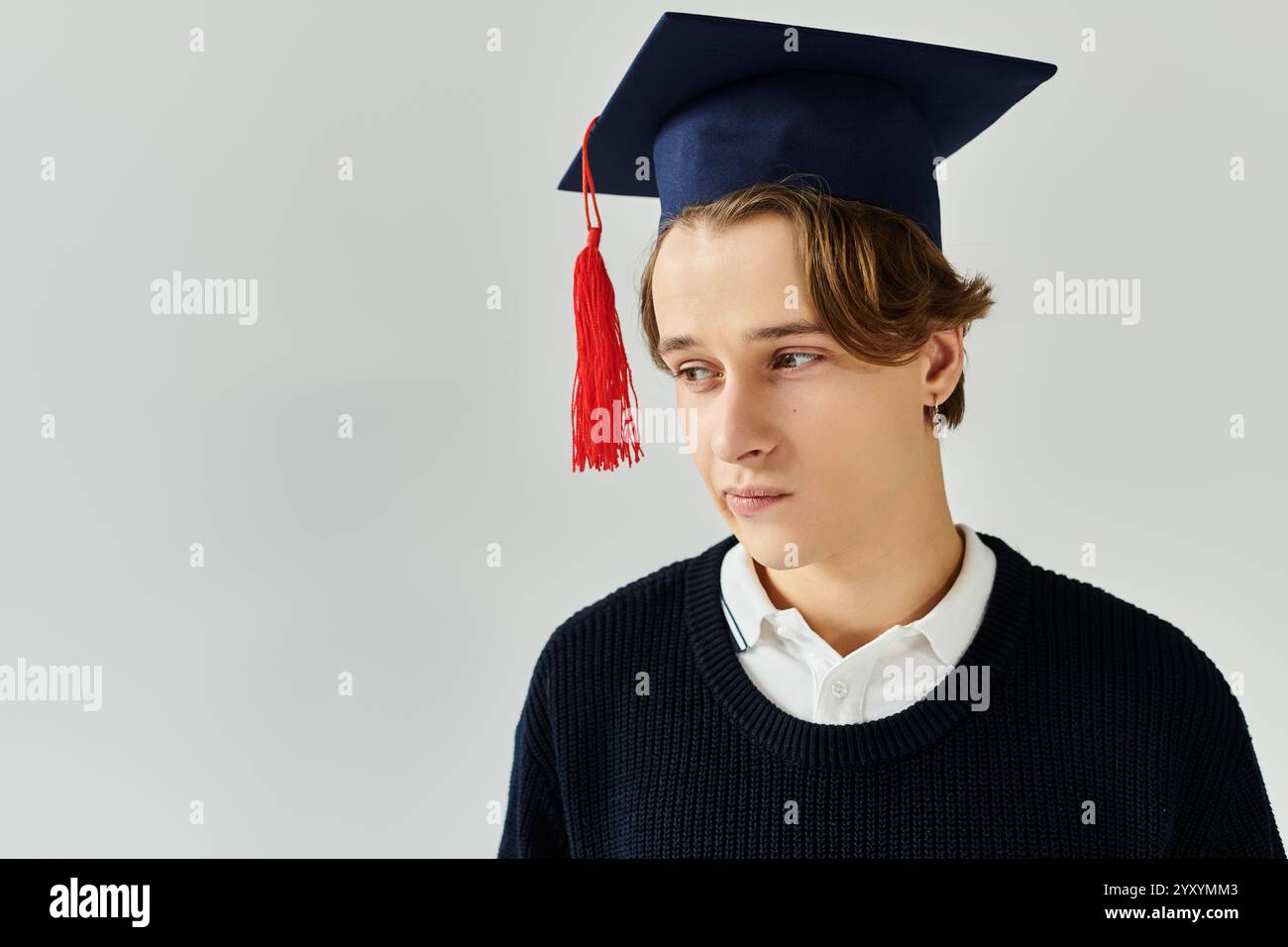 A handsome young student poses confidently in a studio while ...