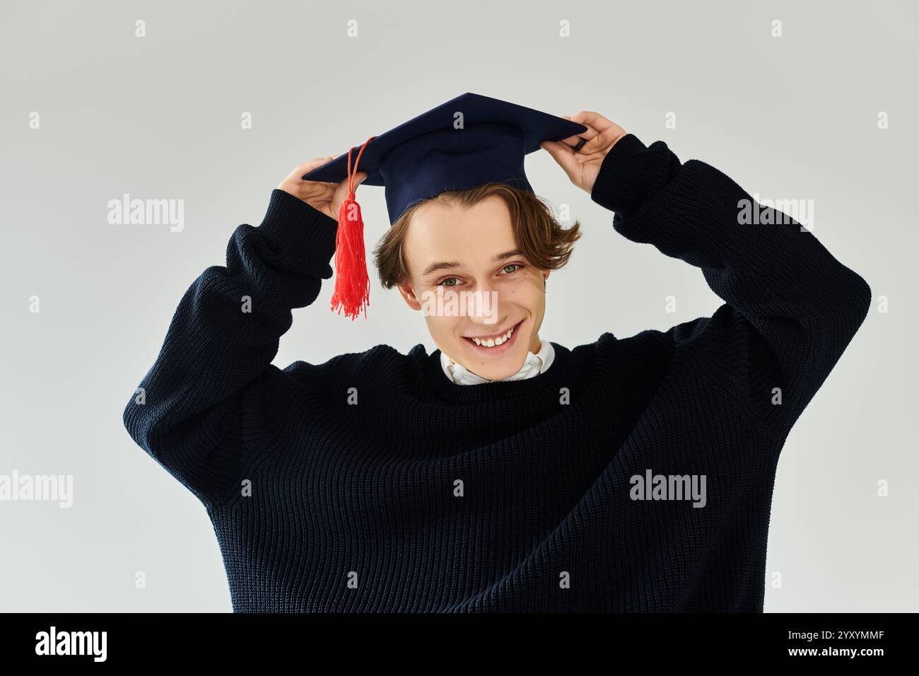 A young student proudly wears his graduation cap, embodying the spirit ...
