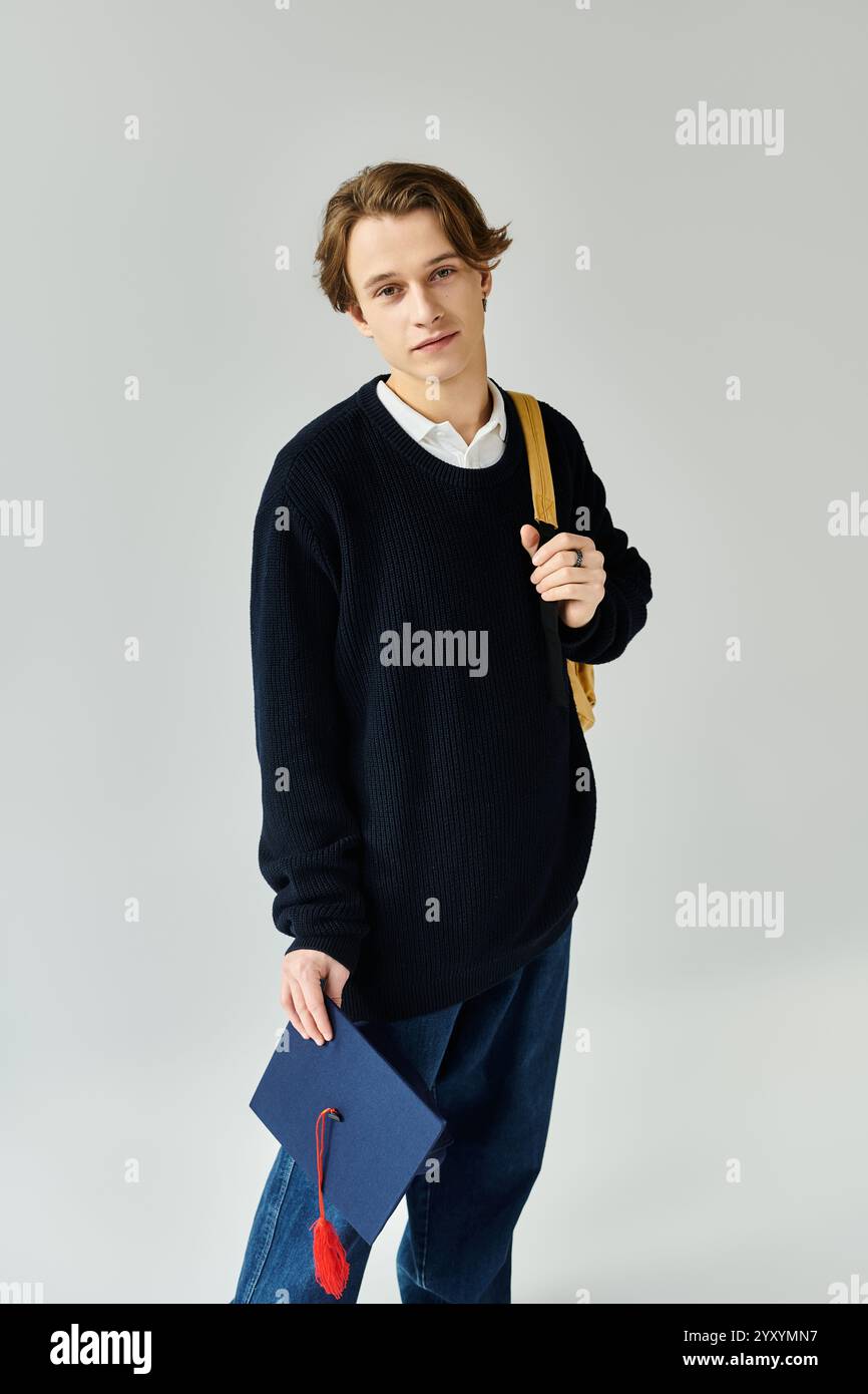 A confident young man proudly poses with his graduation cap in a ...