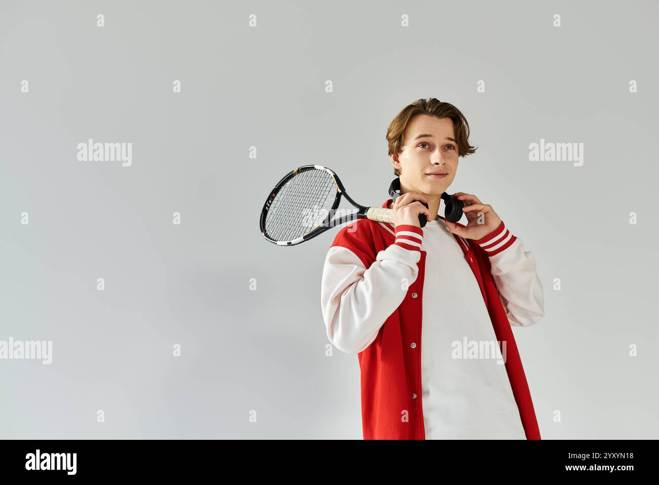 A handsome, young man showcases his fashionable bomber jacket while ...