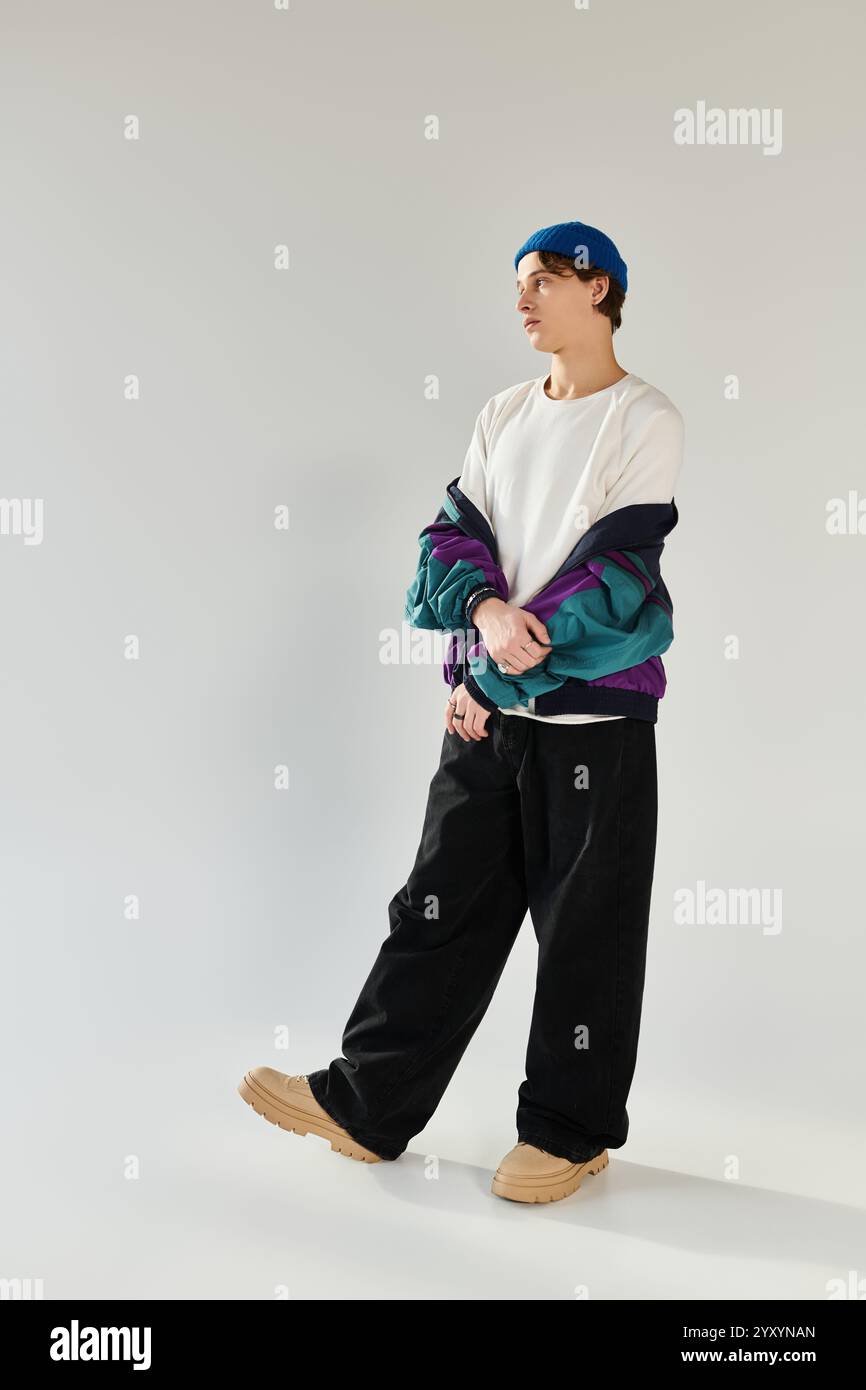 Young student in a fashionable bomber jacket poses thoughtfully in a ...