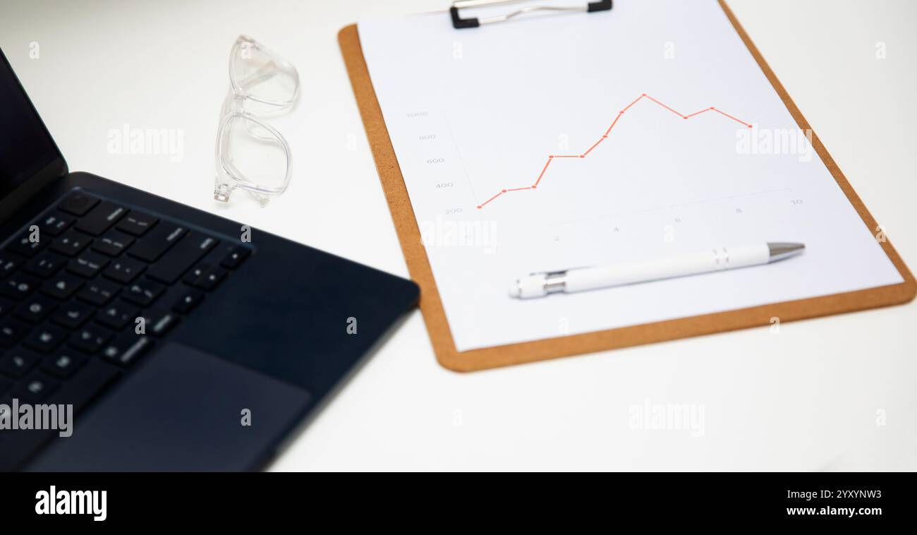 Office workplace table with charts report on wooden clipboard, glasses ...