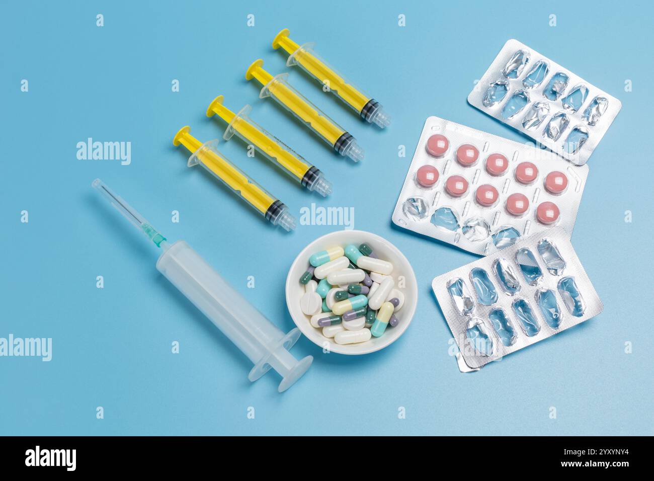 Empty and used medicine blister packs with pink pills and syringes ...