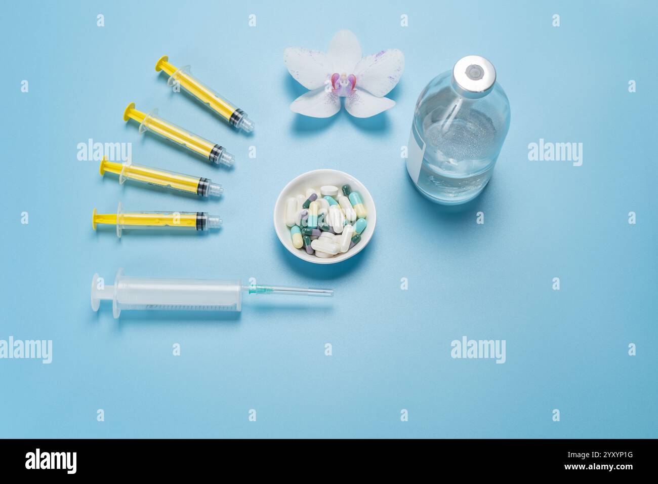Porcelain bowl with different capsules, a glass bottle with liquid ...