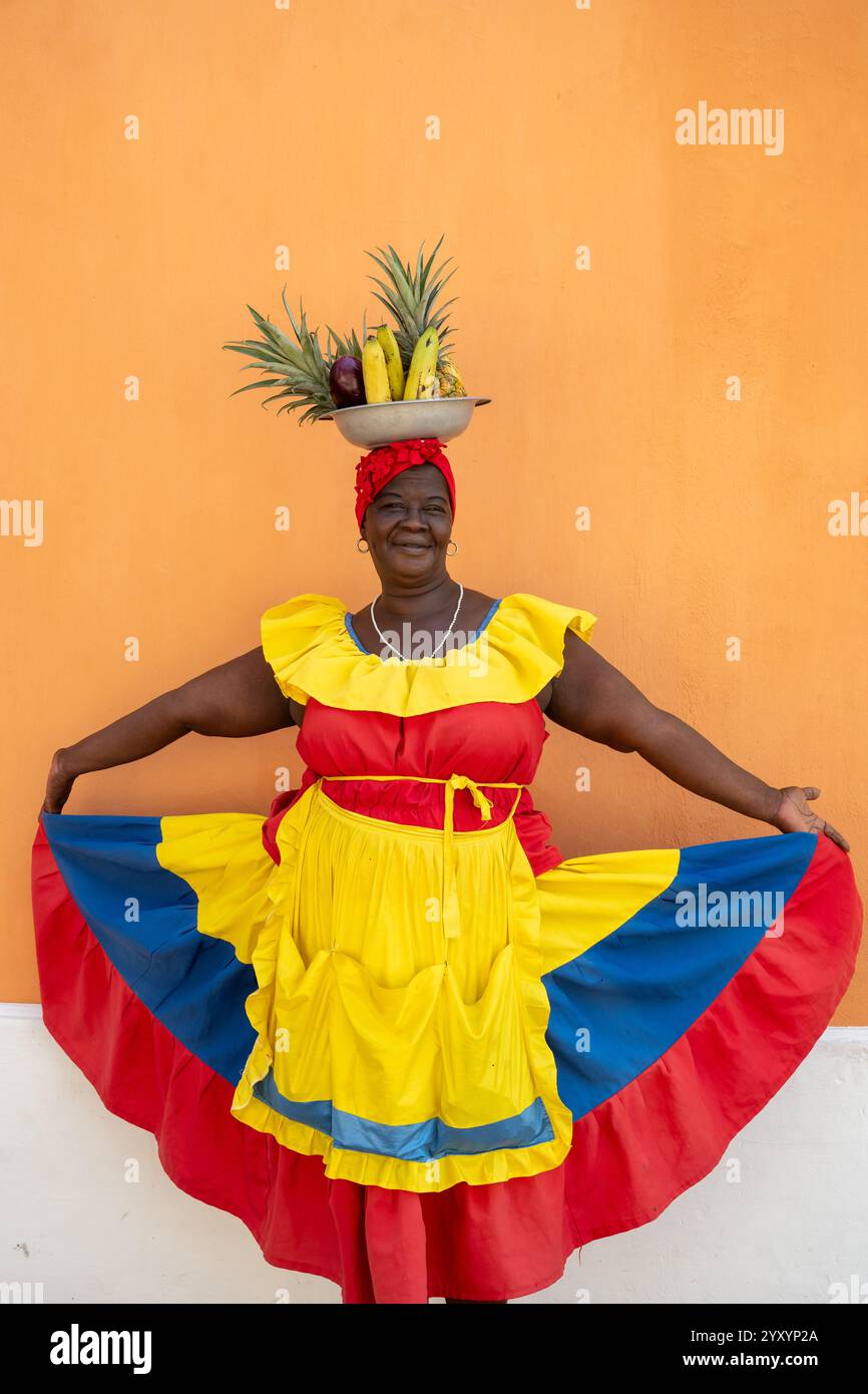 A Palenquera Woman Wearing A Red, Yellow, And Blue Dress, Holding Out ...