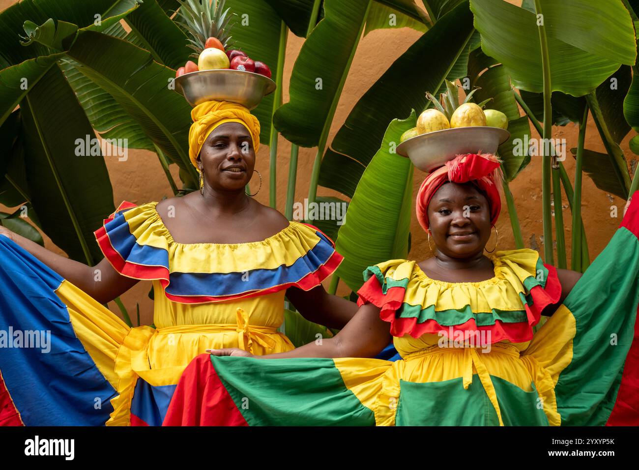Two Palenquera Women Wearing Bright Traditional Dresses Holding Their ...