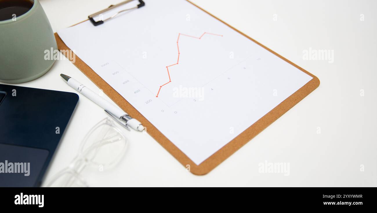 Office workplace table with charts report on wooden clipboard, coffee ...