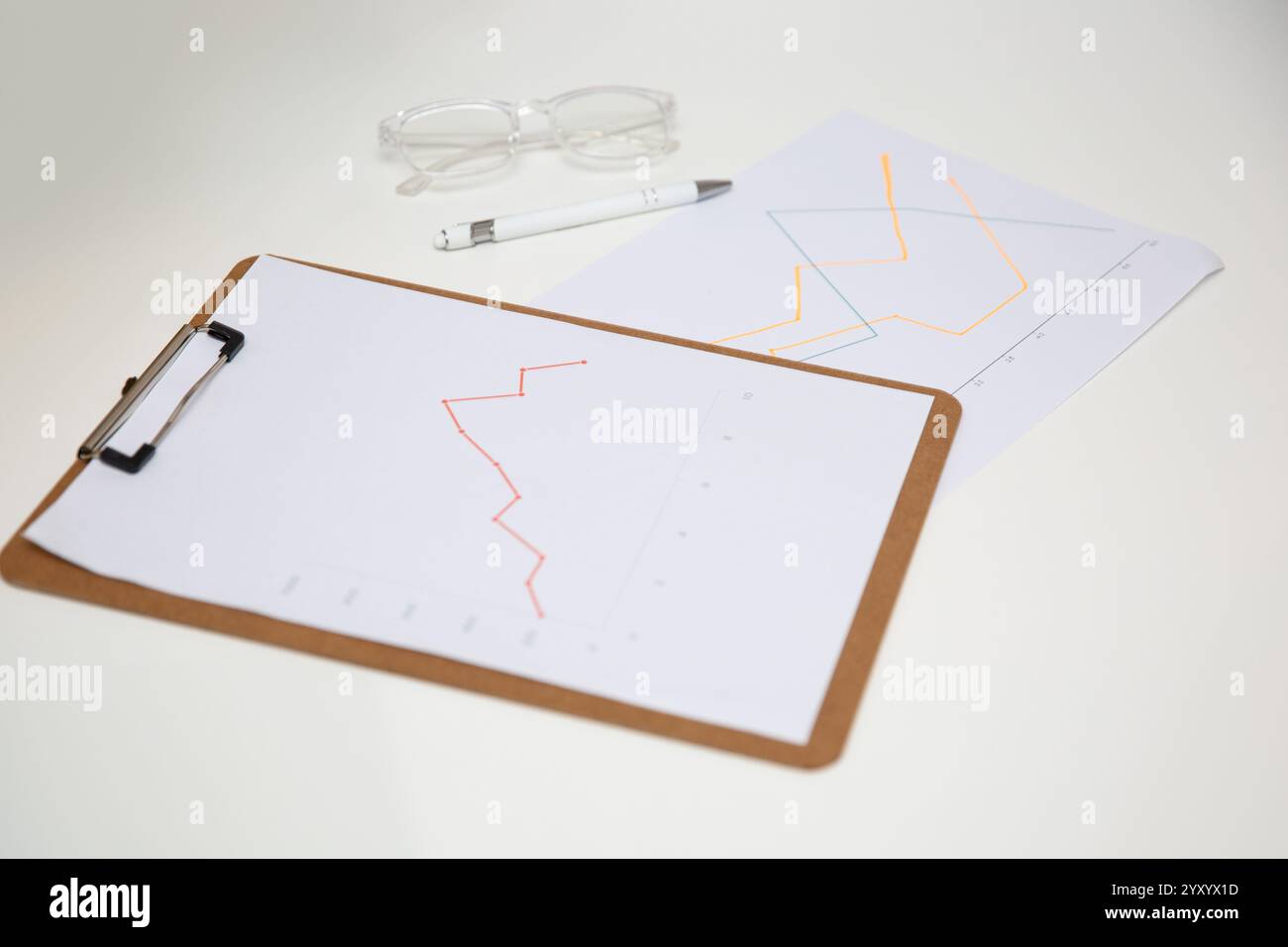 Office workplace table with charts report on wooden clipboard, glasses ...